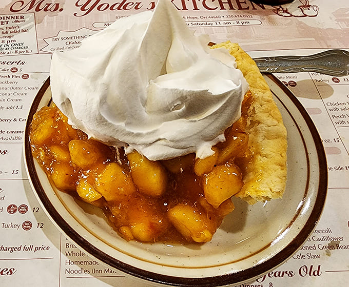 Peach pie that captures summer in every bite, topped with whipped cream that defies both gravity and restraint.
