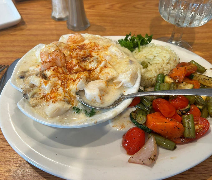 Fresh Atlantic scallops swimming in creamy sauce alongside colorful roasted vegetables equals pure seafood heaven.