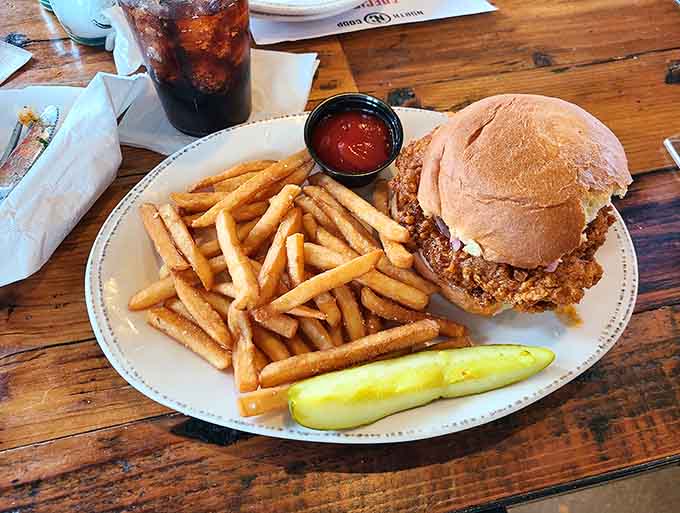 The fried chicken sandwich arrives with a mountain of fries, proving that sometimes the best meals are the ones that don't apologize for being indulgent.