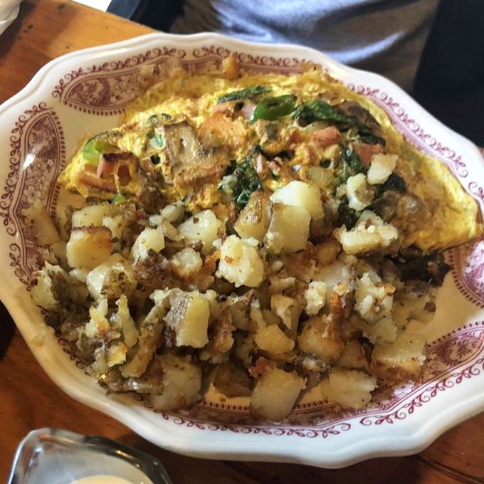 An omelet that puts hotel breakfast buffets to shame, paired with those legendary home fries that steal the spotlight.