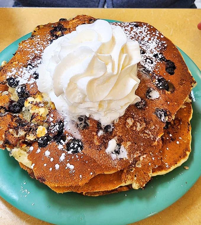 When pancakes wear whipped cream like a crown, you know you're in for a royal breakfast experience that'll have you plotting your next visit.