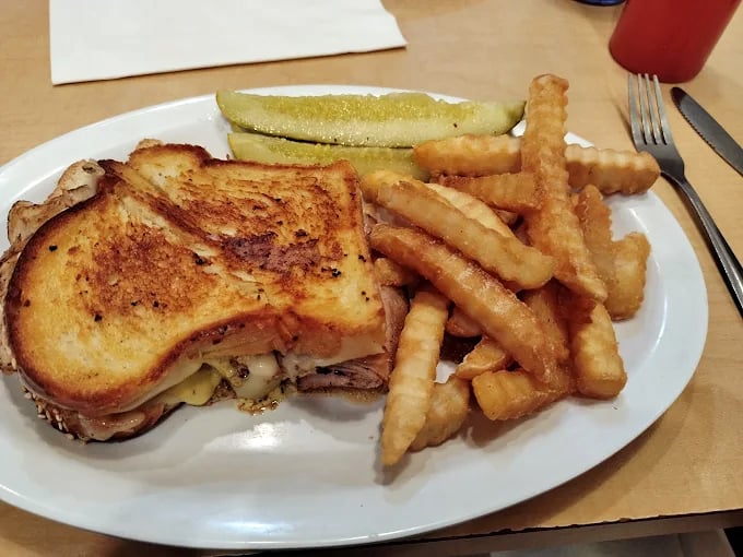 The grilled sandwich glistens with promise, its golden-brown exterior hiding treasures of melted cheese and perfectly seasoned meat.