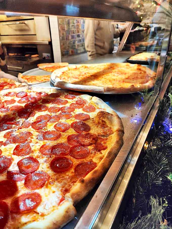 The display case at Joe's is like a museum of edible art &ndash; each pizza a masterpiece waiting to be claimed by the next lucky customer.