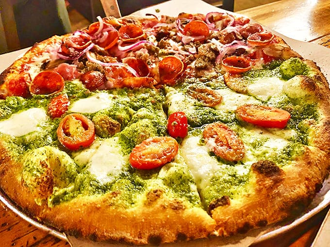 Pollo e Pesto pizza: A vibrant split personality pizza featuring bright basil pesto on one side, classic red sauce on the other. It's like Italy's north and south made peace on a plate.