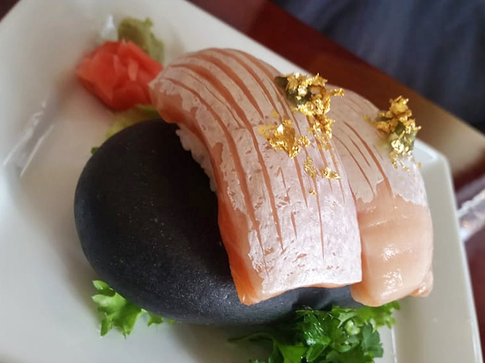 Gold-flecked salmon nigiri that looks like modern art but tastes like butter from the sea. Pure luxury on a black stone.