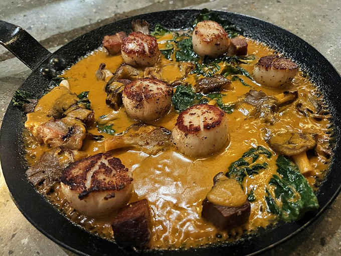 Seared scallops dance in a creamy sauce that might make you forget your table manners as you reach for bread to sop up every last drop.