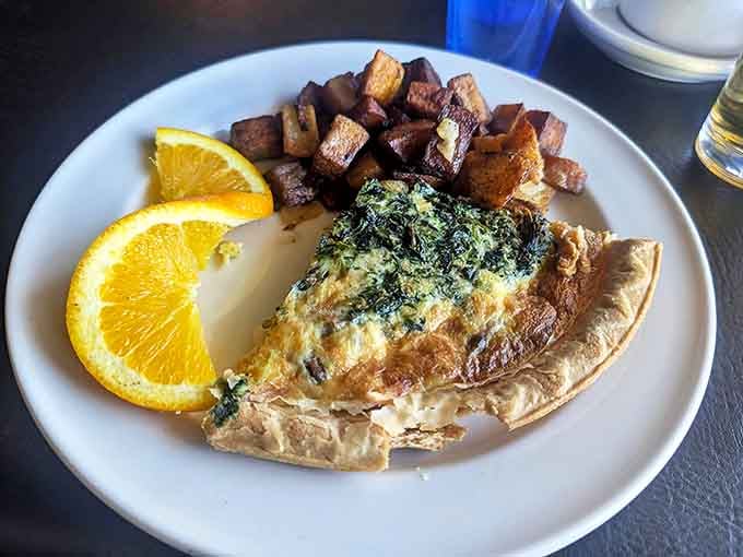 The Spinach Quiche arrives with perfectly seasoned "Paris Potatoes" &ndash; crispy on the outside, tender within, and utterly addictive.