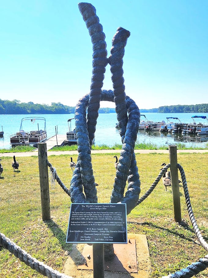 Summer days meet sculptural splendor as boats bob peacefully behind this twisted tribute to scouting tradition.