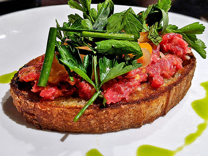 Steak Tartare: Handchopped beef glistens with possibility, flanked by perfectly grilled bread. The kind of dish that converts raw-meat skeptics into true believers.