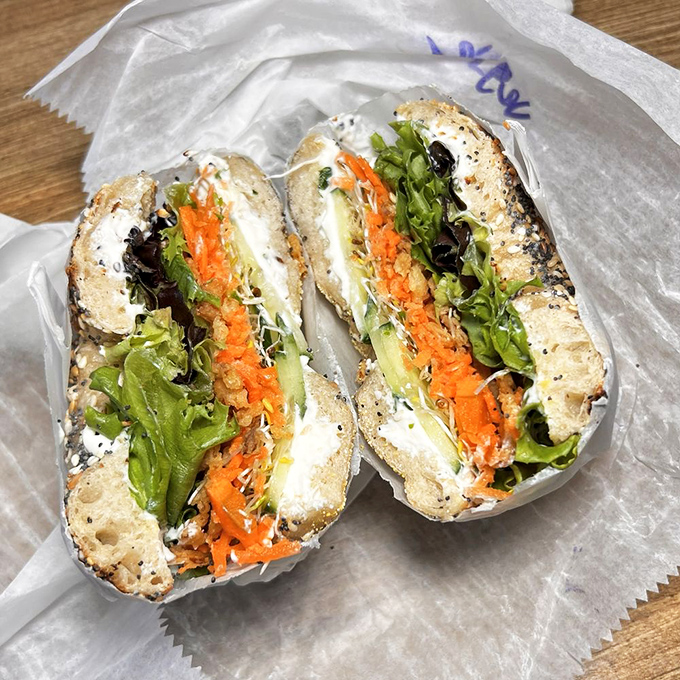 A symphony of fresh ingredients &ndash; cream cheese, vibrant carrots, crisp greens &ndash; all nestled within the perfect vehicle of a wood-fired bagel.