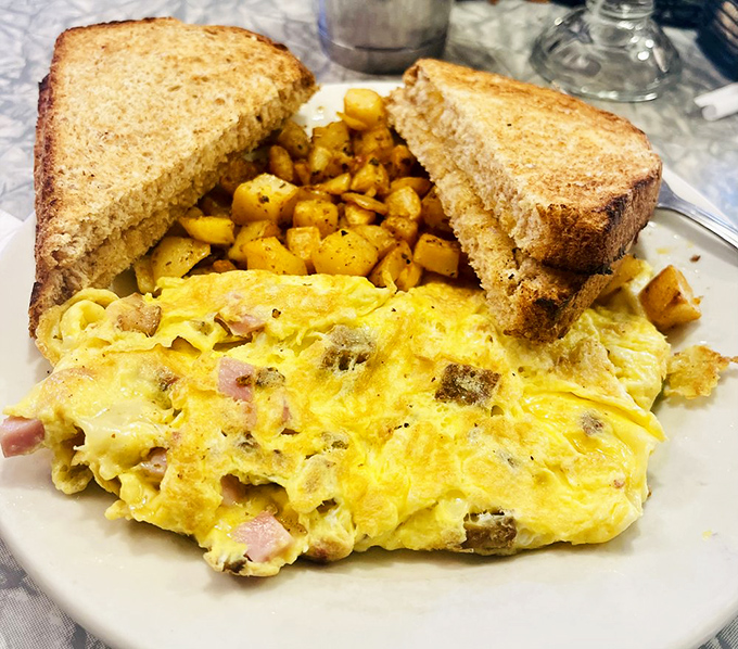 Vermont's famous cheddar stars in this fluffy omelet, packed with diced ham and served alongside golden home fries and buttery toast.