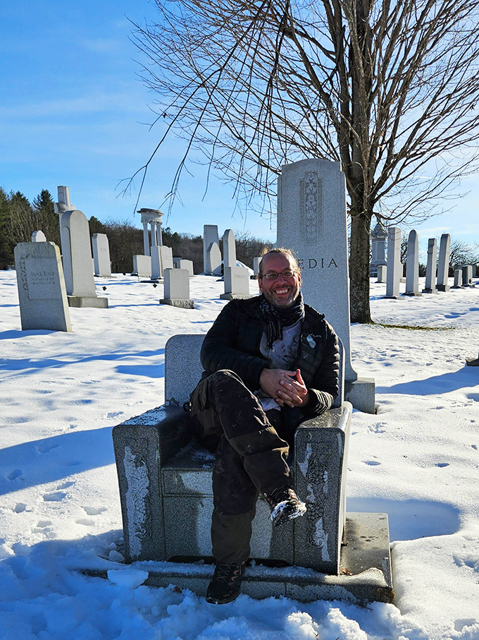 A visitor finds a moment of contemplation in a granite chair, surrounded by the artistic legacy of Barre's master stonecutters.