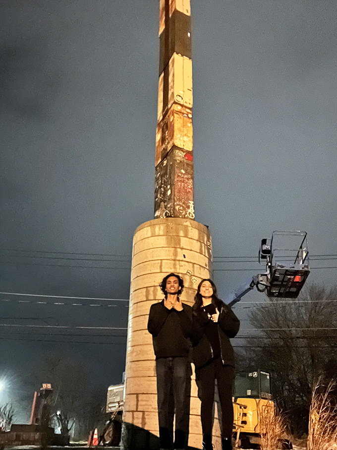 Visitors gather at the base, necks craned upward, contemplating this peculiar stack of metal drawers reaching for the clouds.