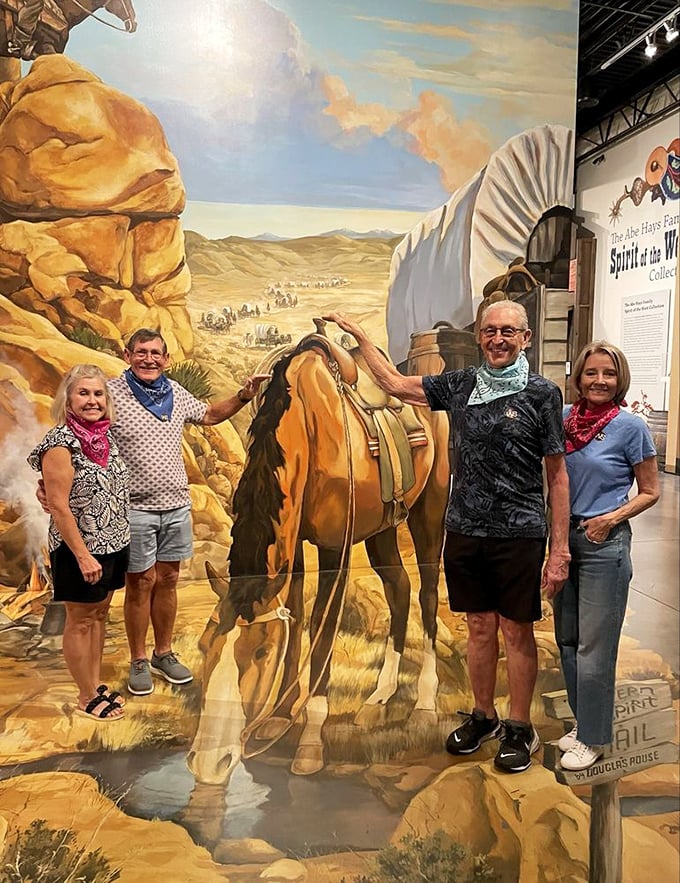 Visitors pose with an interactive exhibit that brings Western trail scenes to life &ndash; no horse required!
