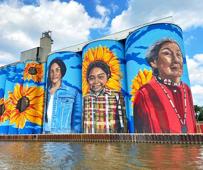 The mural's scale becomes apparent when you notice the tiny lift carrying artists, like watching a hummingbird decorate a mountain.