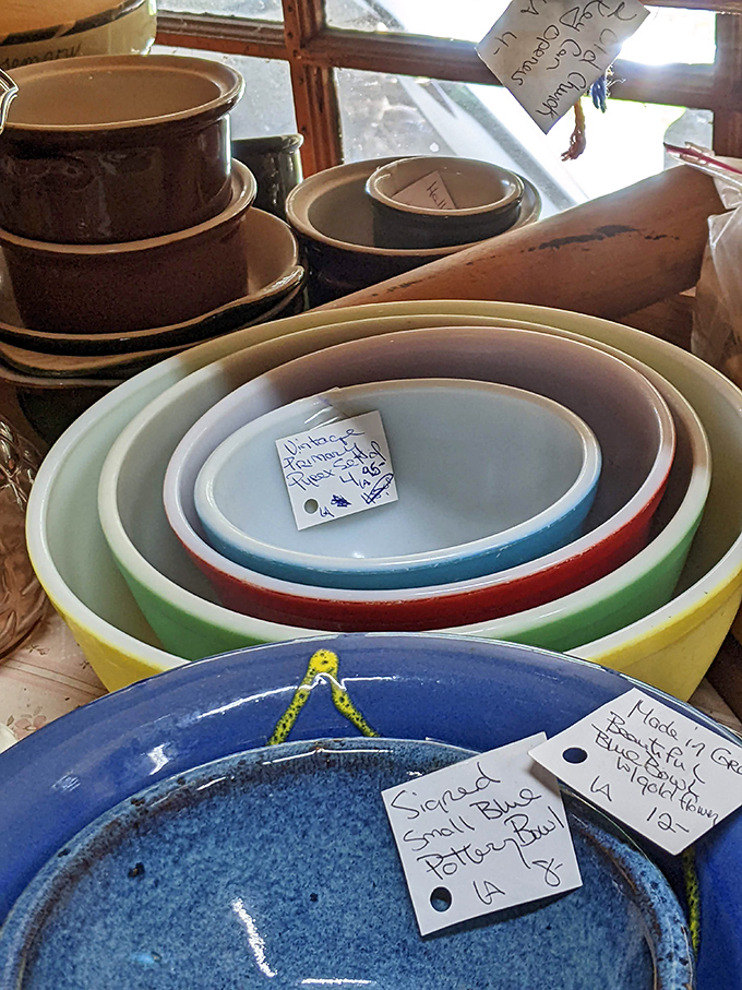 Colorful vintage Pyrex mixing bowls stack like a rainbow of kitchen nostalgia, each chip and scratch a testament to family meals prepared.