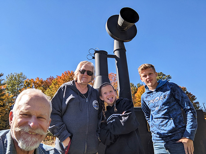 Visitors gather around the massive telephone monument, providing perfect scale reference and showing the delight it brings to roadside explorers.