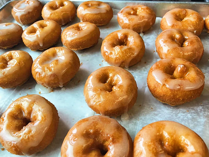 Golden-brown glazed beauties glisten in the light, their perfect size promising guilt-free indulgence – or permission to try several flavors. Photo credit: <a href="https://maps.google.com/maps/contrib/105677120056399481427" target="_blank" rel="noopener noreferrer">Peace, Love and Little Donuts of Traverse City</a>