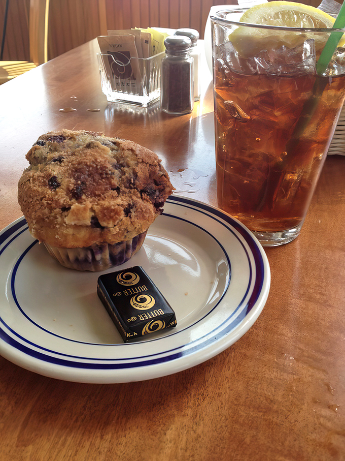 Their legendary blueberry muffin sits proudly on the plate, its golden crown promising bursts of wild Maine blueberries in every heavenly bite.