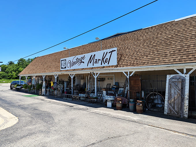 Under clear Michigan skies, the market's exterior serves as the first gallery space &ndash; vintage treasures spilling onto the covered walkway, beckoning curious travelers.