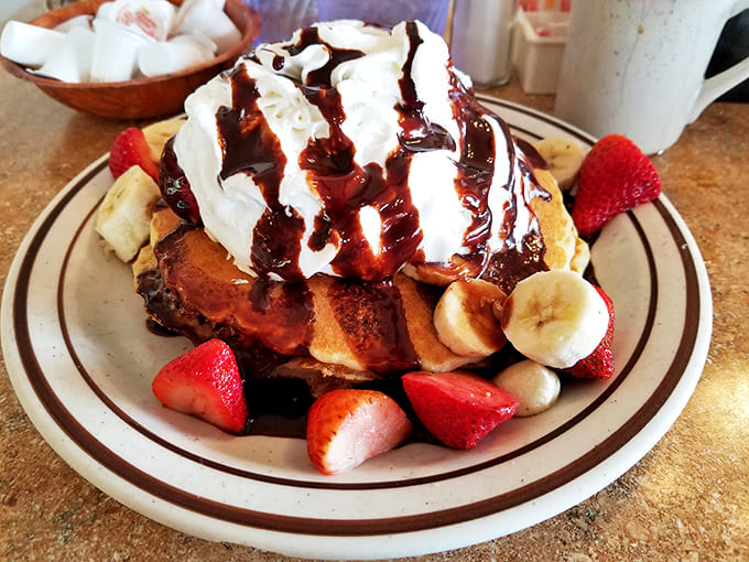 Sweet tooth heaven! These pancakes, topped with fresh fruit and whipped cream, aren't just breakfast – they're an edible hug.