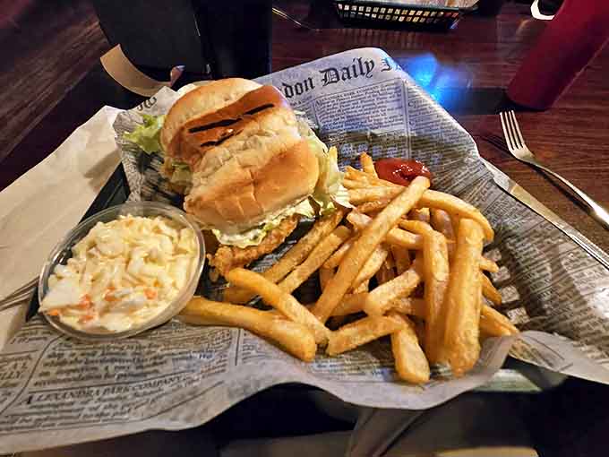 A hearty sandwich served on newspaper with golden fries and creamy coleslaw &ndash; comfort food that speaks a universal language.