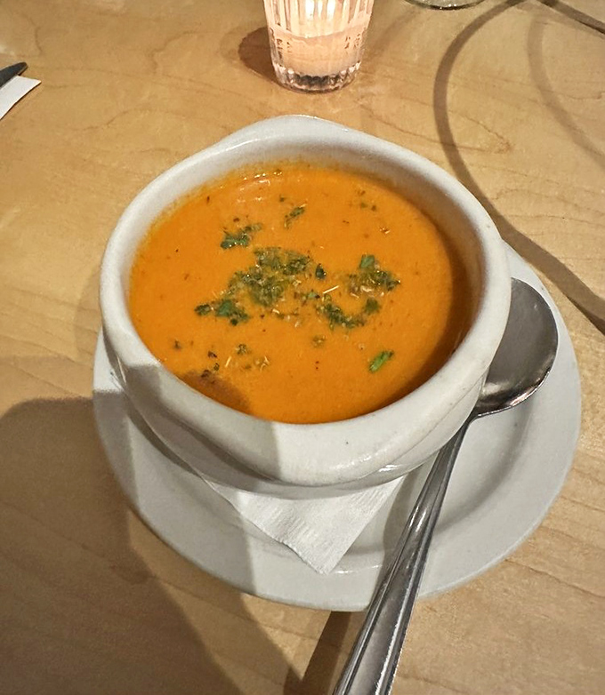 This vibrant tomato soup isn't just orange&mdash;it's practically performing a Broadway show of flavor in a humble white bowl.