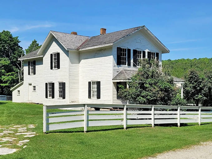 A classic white farmhouse with picket fence stands in stark contrast to workers' quarters, a visual reminder of the social hierarchy that defined Fayette.