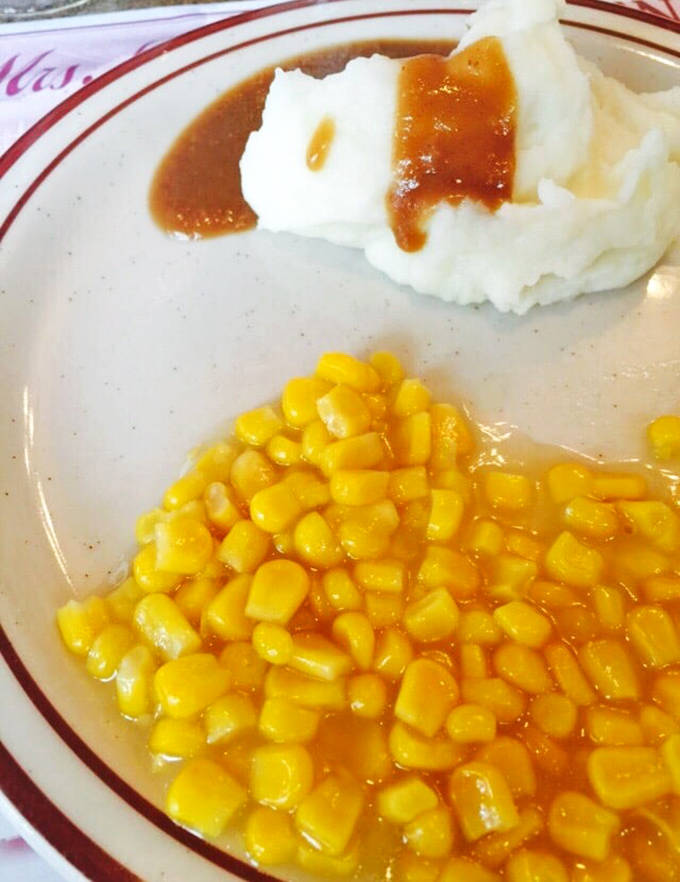 Sweet yellow corn glistens beside a mountain of mashed potatoes, a simple combination that somehow manages to taste like childhood memories and summer sunshine.