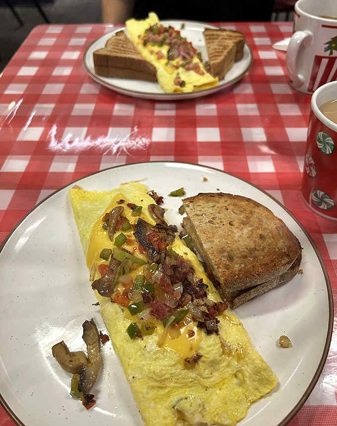 Omelet artistry at its finest &ndash; fluffy eggs cradle a medley of fresh vegetables, meats and cheese alongside perfectly toasted bread.