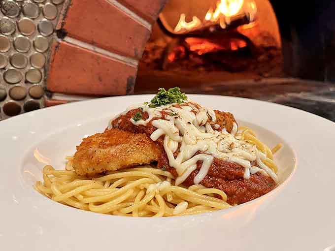 Golden-fried chicken parmesan over spaghetti brings Italian comfort food to the Midwest with melted cheese and marinara magic.
