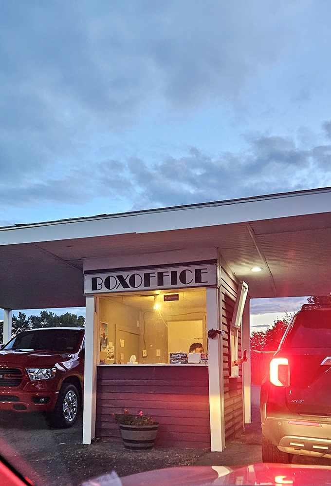 The retro box office booth welcomes moviegoers with a warm glow, a portal between everyday life and cinematic escape.