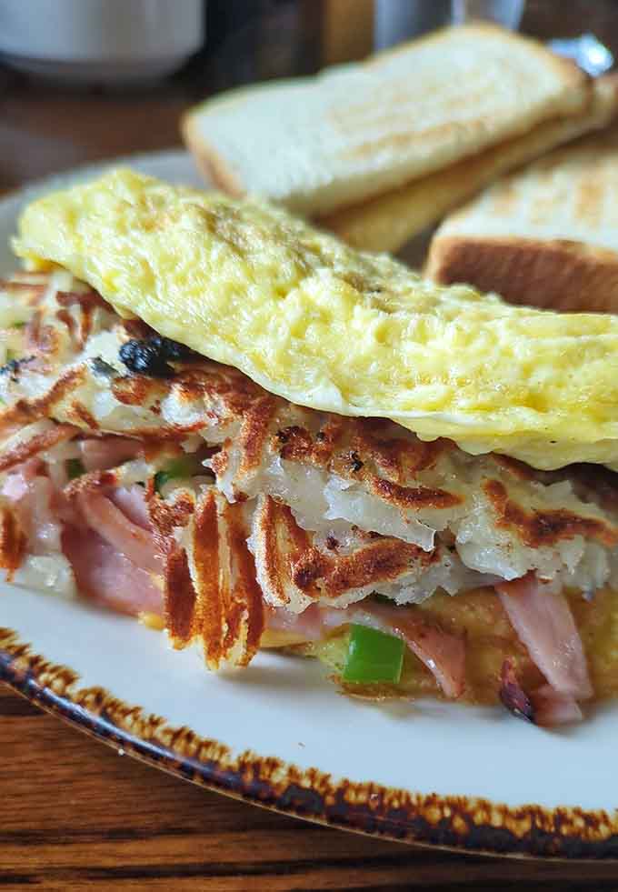 The Build Your Own Omelet option lets you create breakfast perfection, here shown with ham and peppers alongside crispy hash browns and toast.