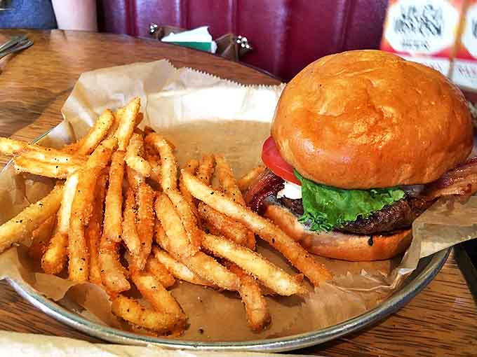 A perfectly proportioned burger sits beside golden fries, demonstrating that HopCat knows its way around more than just cheese.