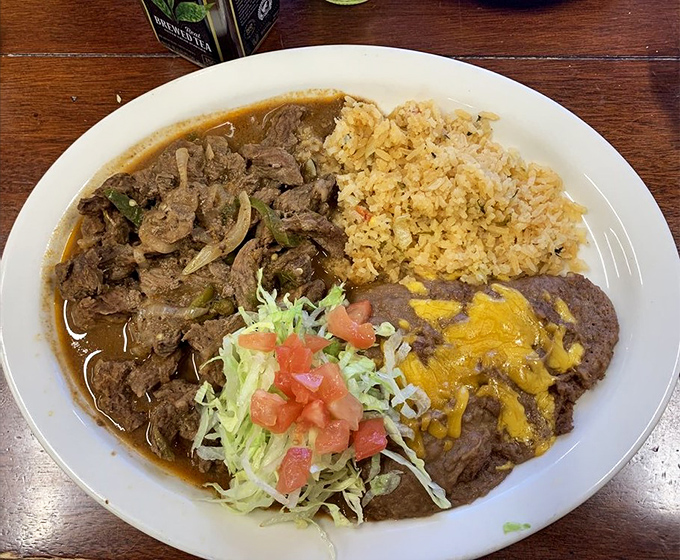 Carne Ranchera plate: A symphony of flavors on a single plate &ndash; spiced meat, velvety beans, and perfectly cooked eggs creating harmony with every bite.