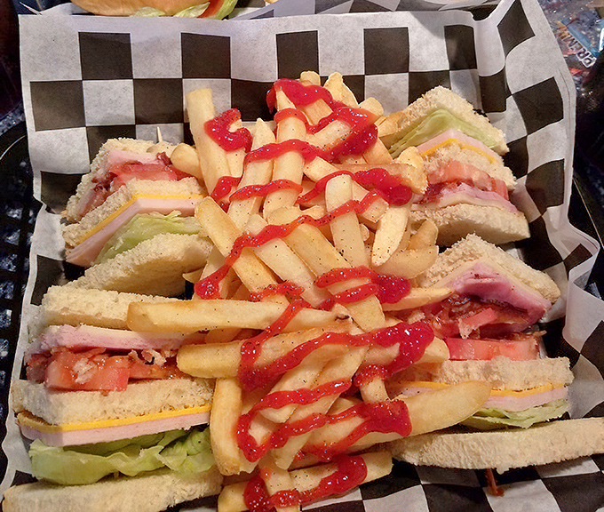 The club sandwich stands tall like a Saturn V rocket, layers of meat and veggies between bread, with fries drizzled in ketchup for extra launch power.