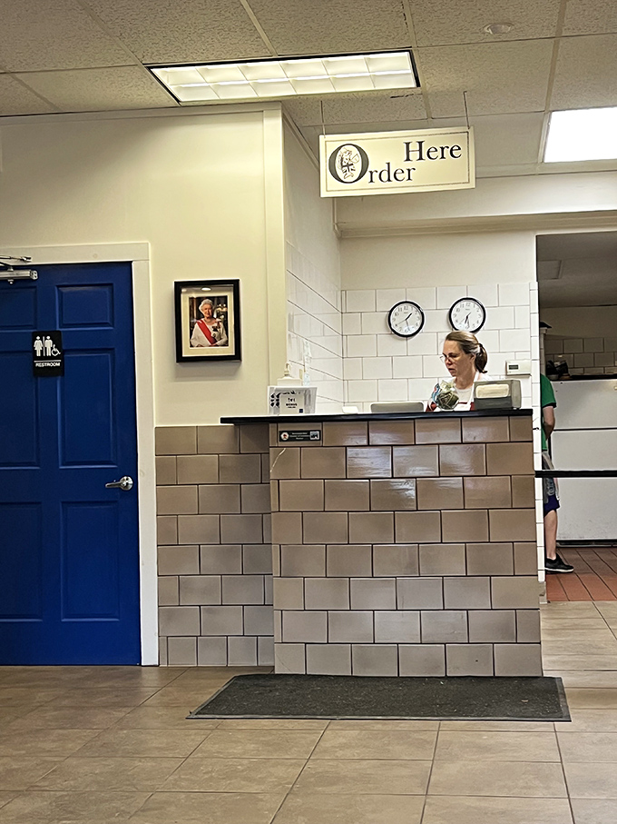 The ordering counter, crowned with a simple "Here Order" sign, maintains the unpretentious charm of an authentic British chip shop.