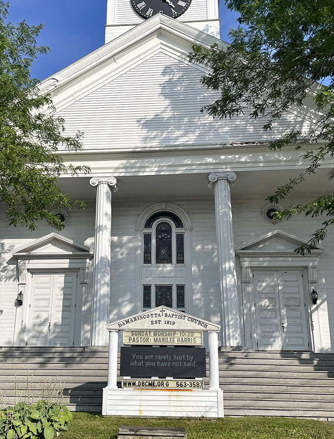 The white steeple of Damariscotta Baptist Church stands as a classic New England landmark against the perfect blue Maine sky.