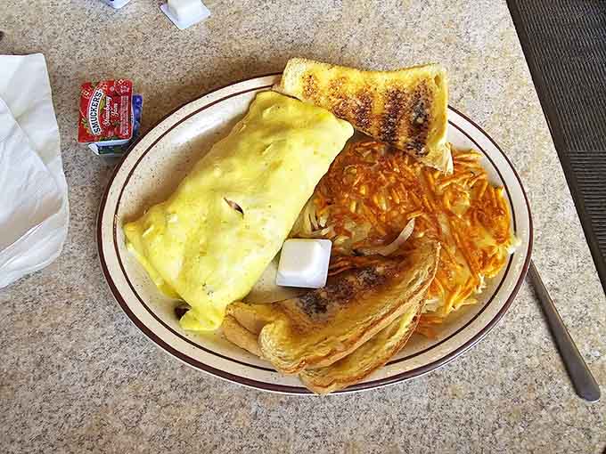 An omelet so fluffy and generous it practically requires an engineering degree to navigate, but the delicious journey is worth every bite.