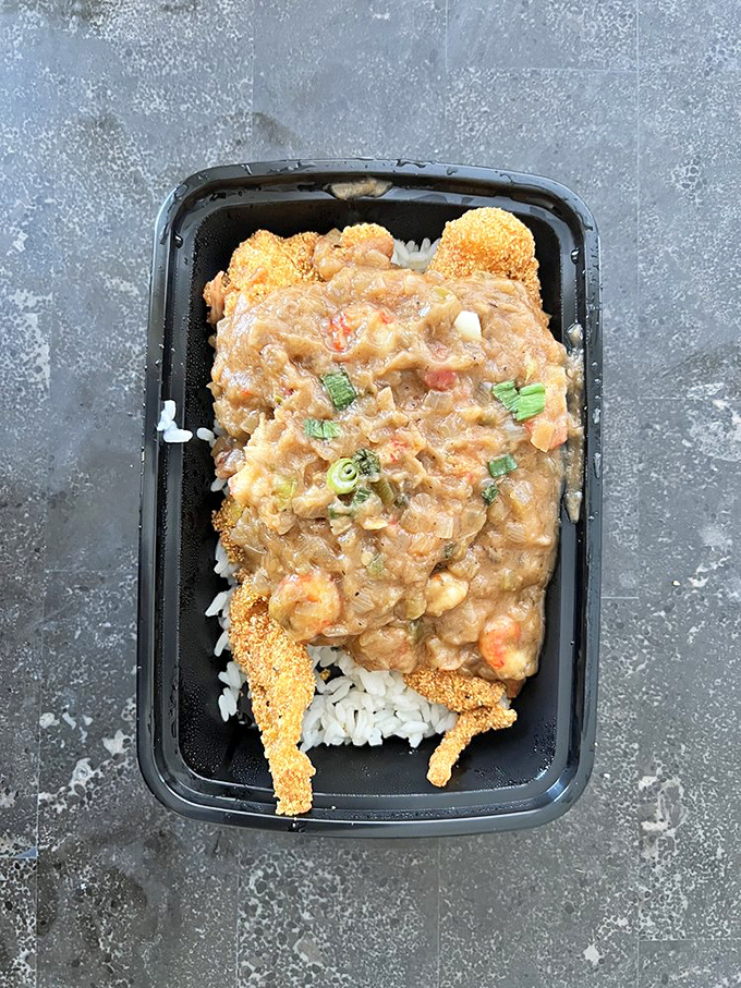 Crispy cornmeal-crusted catfish resting on a bed of rice, smothered in crawfish &eacute;touff&eacute;e&mdash;a match made in Southern heaven.