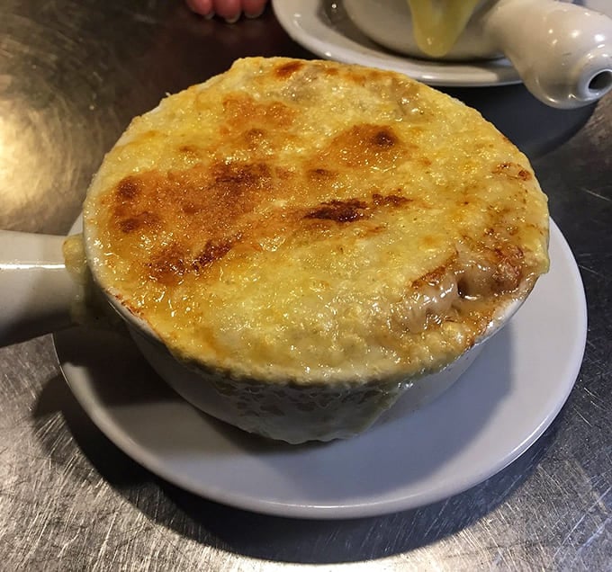 That golden cheese cap hiding sweet caramelized onions and savory broth is basically a warm hug in a crock.
