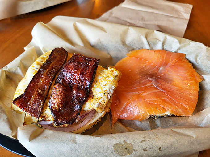 Breakfast decadence: crispy bacon and farm-fresh egg meet smoked salmon on a Montreal-seasoned bagel &ndash; morning glory on parchment.