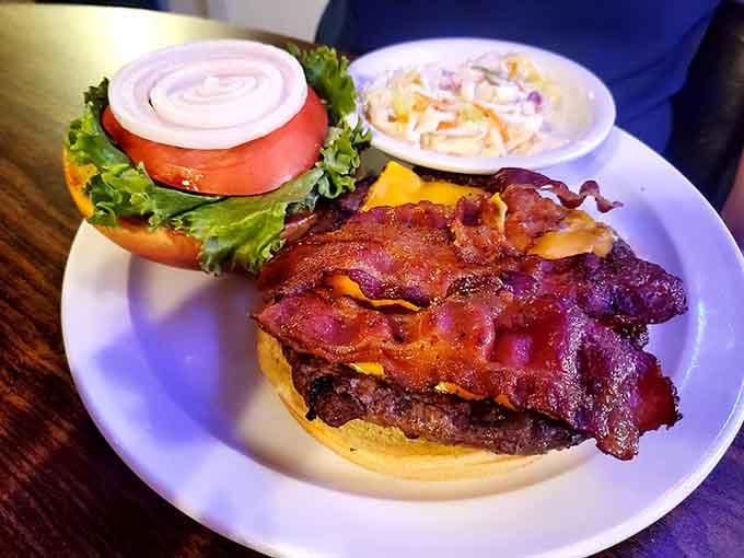 That bacon cheeseburger is stacked so high it practically needs its own zip code, and yes, you'll need both hands for this one.