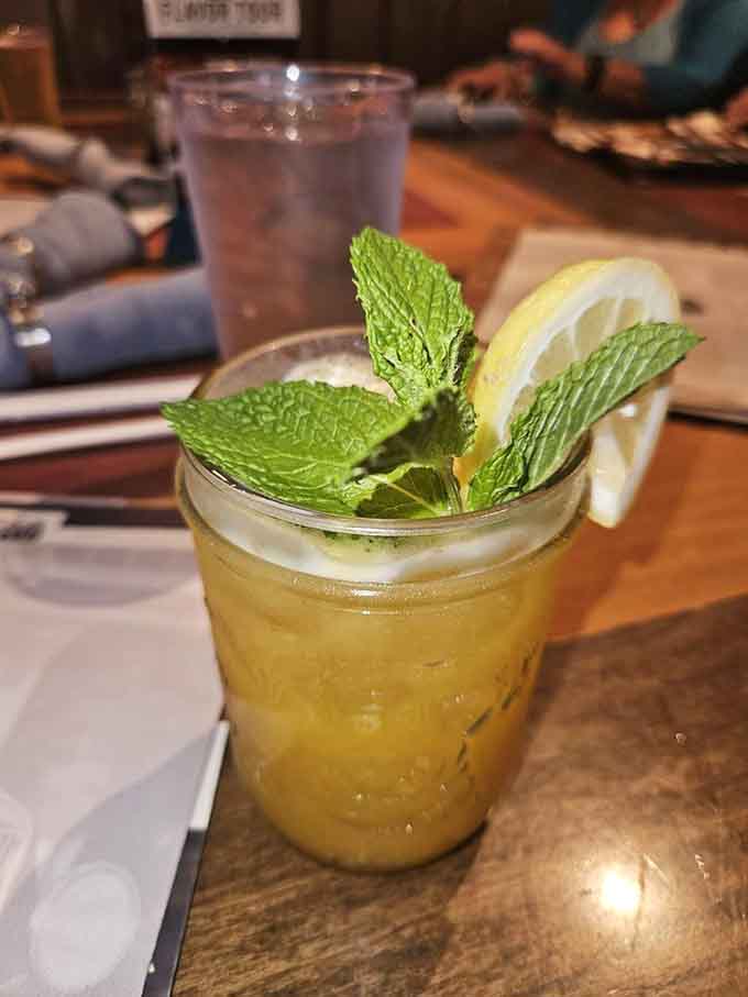 The Backseat Driver cocktail brings tropical mango vibes with fresh mint, offering refreshment between bites of hearty American fare.