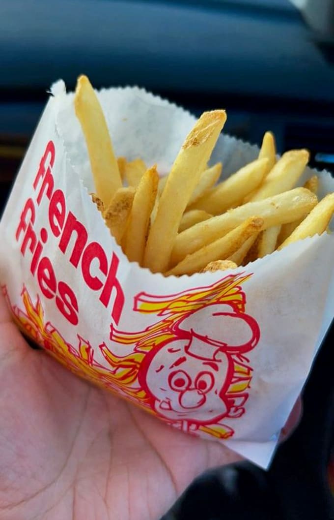 Golden, crispy French fries served in their own little paper bag, because some traditions are too perfect to mess with.