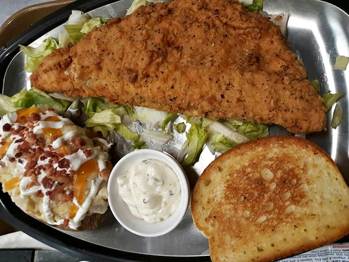 This platter means business with its golden catfish, loaded potato, and enough variety to keep every bite interesting.