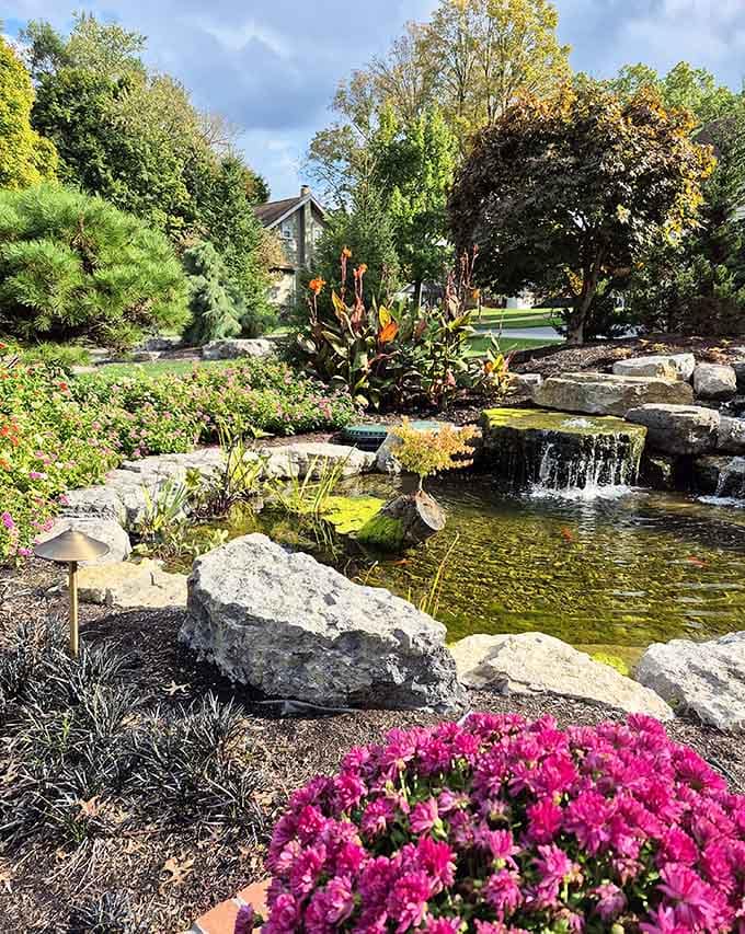 Cascading waterfalls and vibrant blooms frame this serene pond like nature decided to show off its interior decorating skills, and honestly, nailed it.