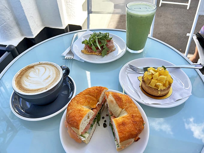 A feast for both eyes and stomach: artisanal sandwich on a golden croissant, perfect latte art, mango-topped dessert, and green smoothie &ndash; breakfast nirvana achieved!