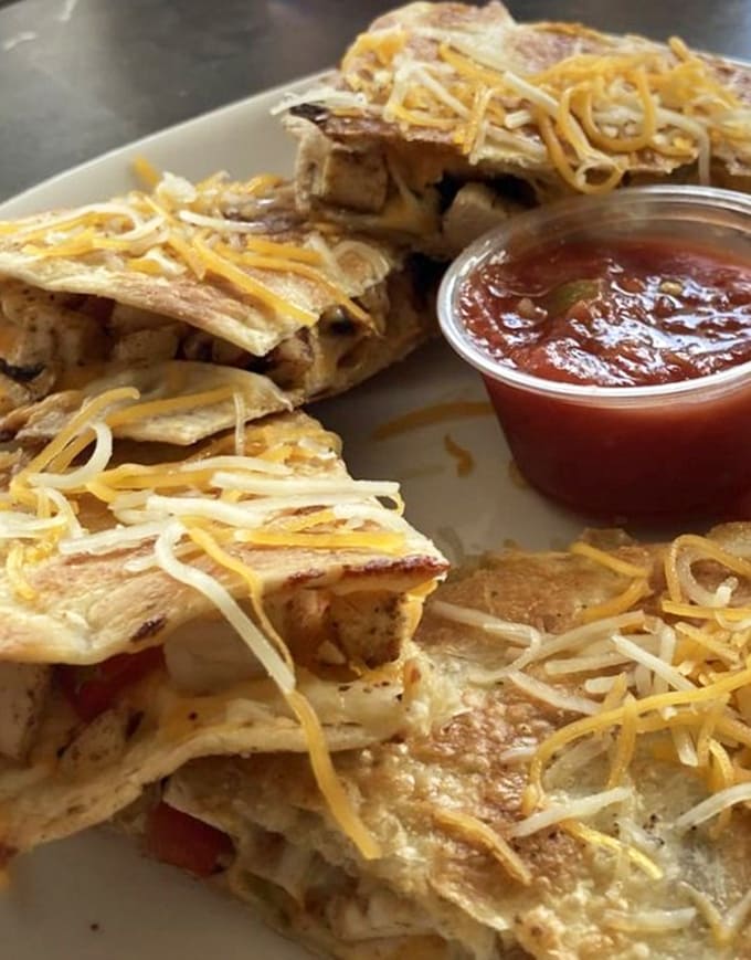 Chicken quesadilla wedges stacked high and oozing cheese, because sometimes you need a break from wings to appreciate other melted masterpieces.
