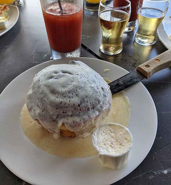 A cinnamon roll so massive it requires its own zip code, swimming in a pool of sweet glaze.